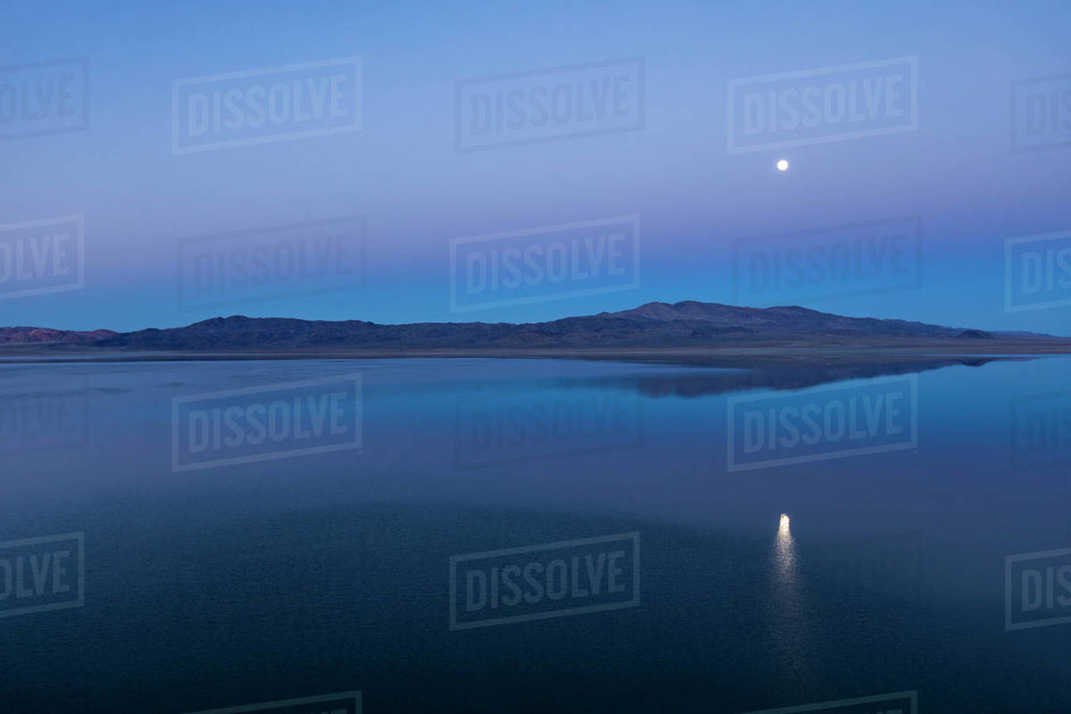 USA, Nevada, Hawthorne, Calm Walker Lake reflecting Moon at dusk ...