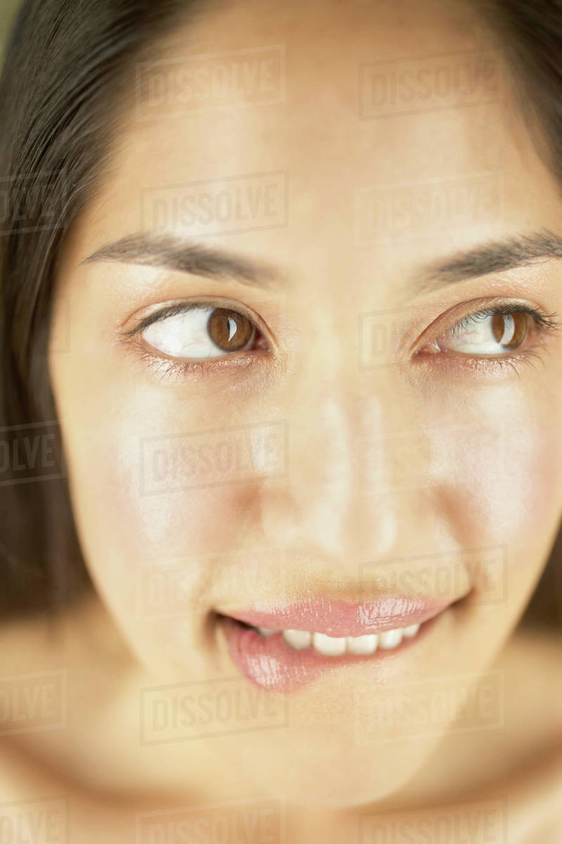 Close-up of woman biting lips - Stock Photo - Dissolve