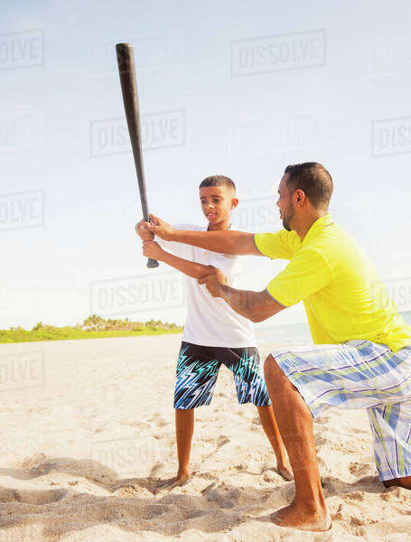 Father and son (10-11) playing baseball on beach - Royalty-free Stock ...