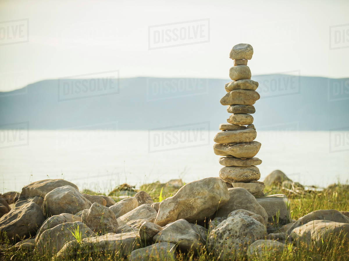 Stack of stones by lake - Stock Photo - Dissolve