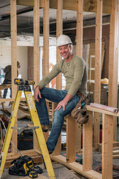 Portrait of construction worker sitting inside new structure - Royalty ...