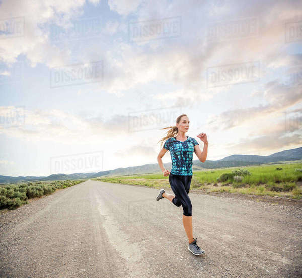 United States, Utah, Cedar Fort, Woman jogging on road in desert ...