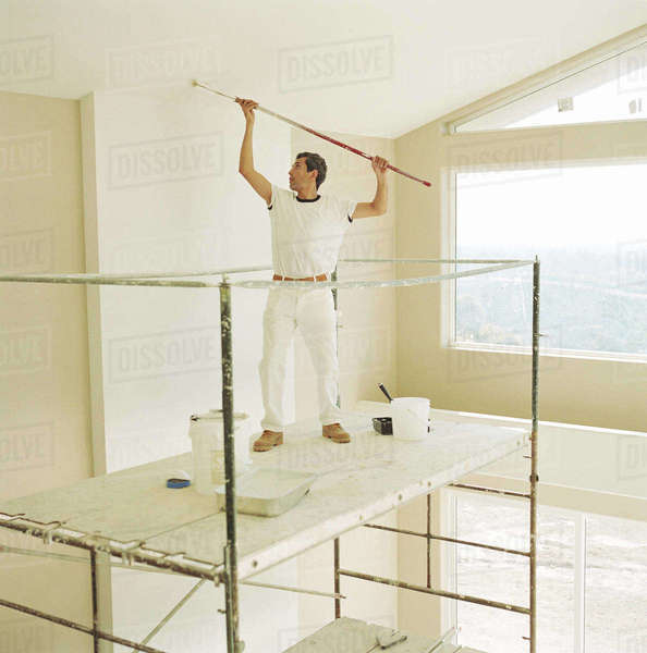 Painter on scaffolding using roller to paint ceiling - Royalty-free ...