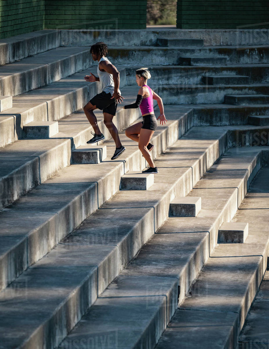 Man and woman jogging up steps - Royalty-free Stock Photo | Dissolve