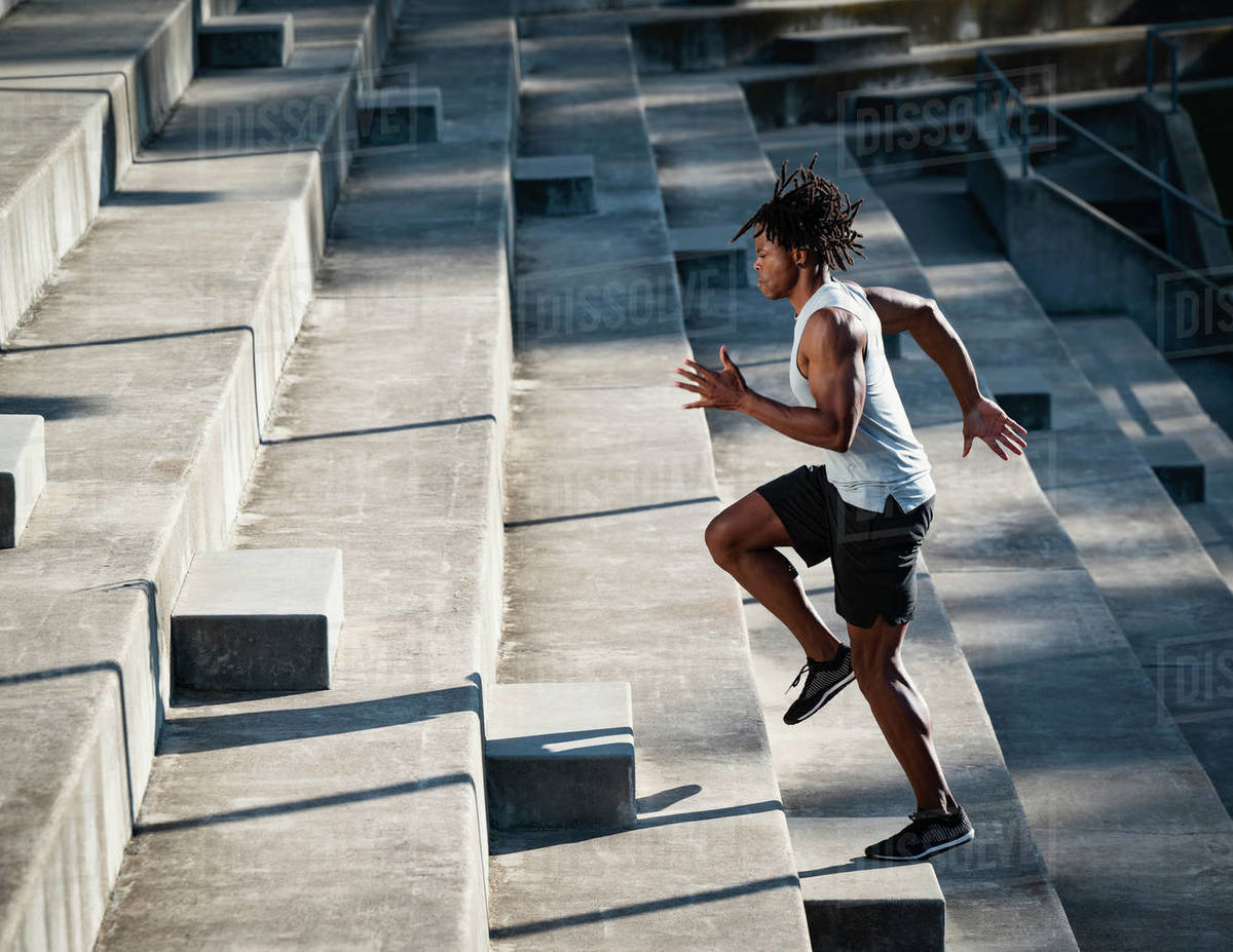Athletic man running up steps - Royalty-free Stock Photo | Dissolve