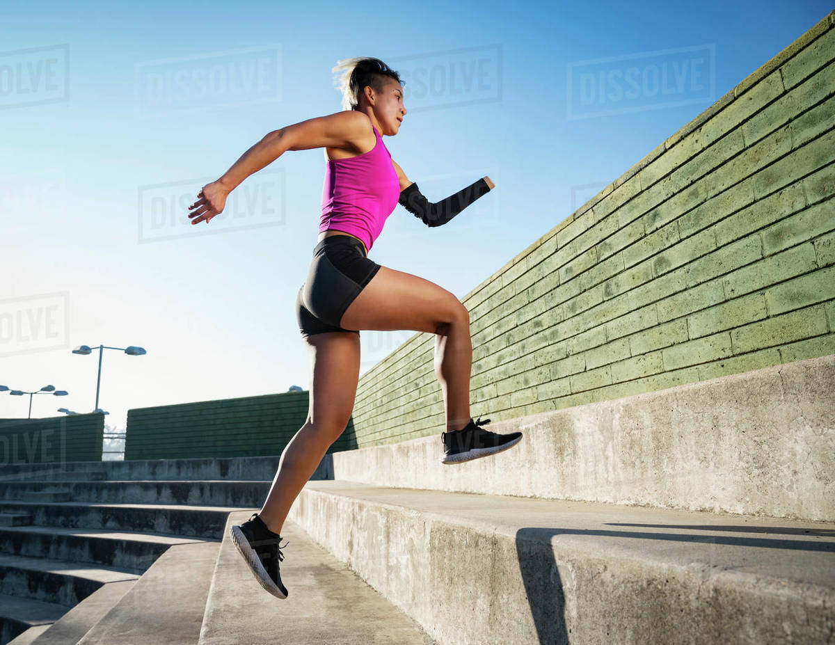 Athletic woman with amputated hand running up steps - Royalty-free ...