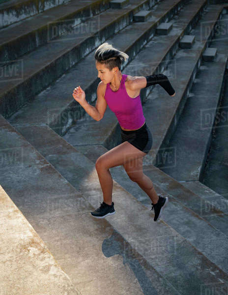Athletic woman with amputated hand running up steps - Royalty-free ...