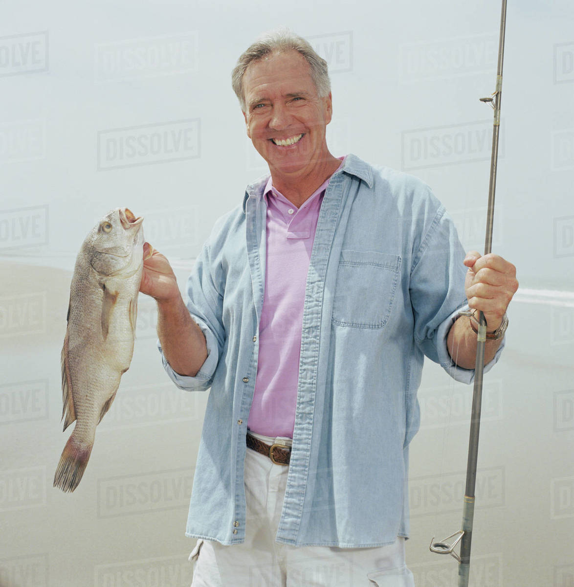 Portrait of smiling fisherman holding catch - Stock Photo - Dissolve