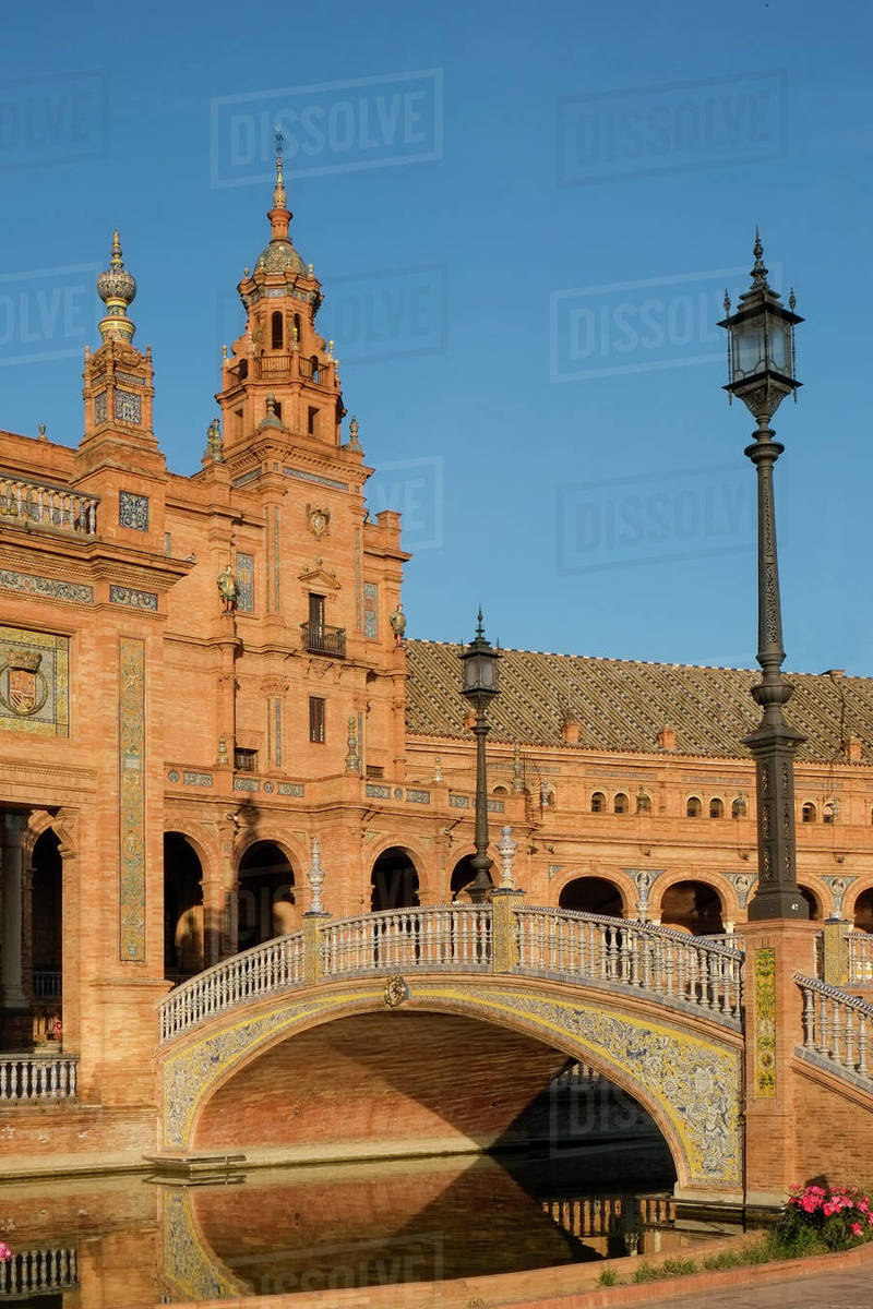 Spain, Seville, Arch bridge over canal and brick church in background ...