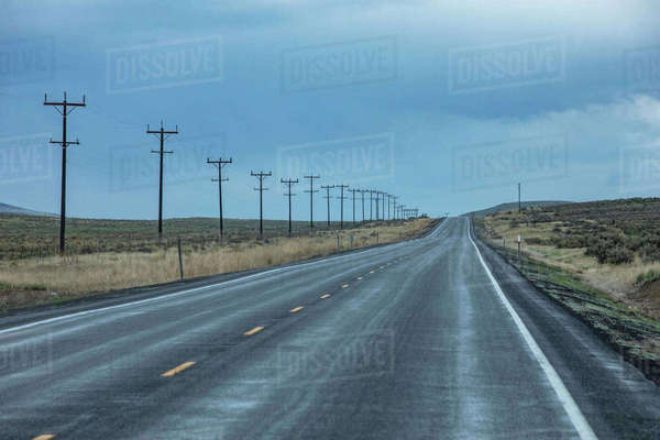 USA, Nevada, McDermitt, Electricity pylons along highway during stormy ...