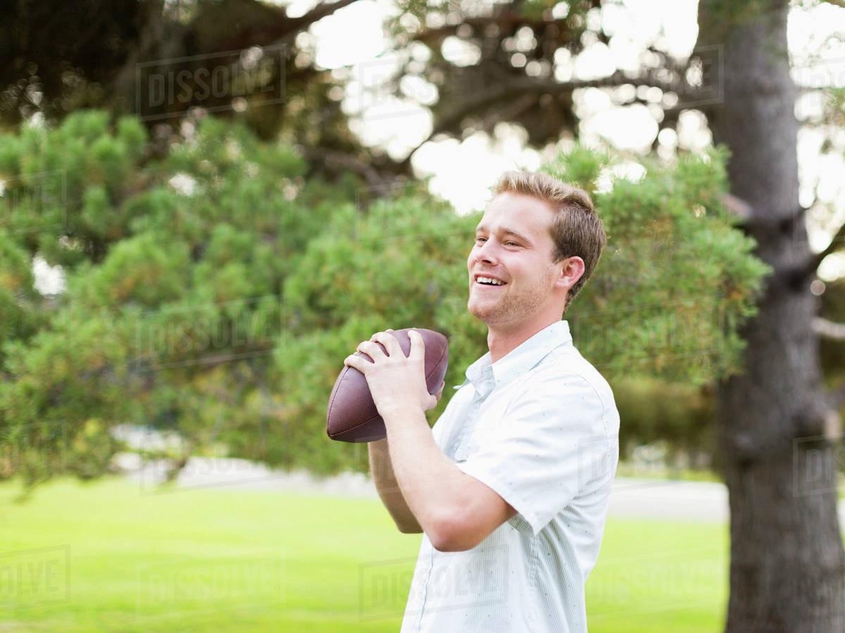 Portrait of young man playing football in park - Royalty-free Stock ...