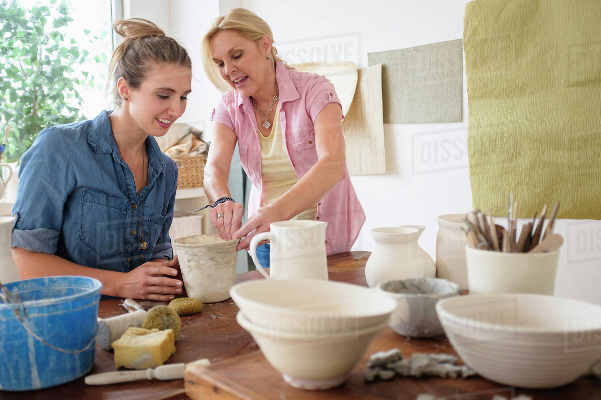 Two women making pottery in studio - Royalty-free Stock Photo | Dissolve