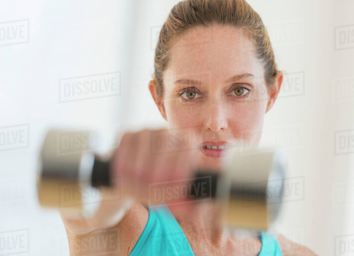 Woman exercising with weights - Stock Photo - Dissolve