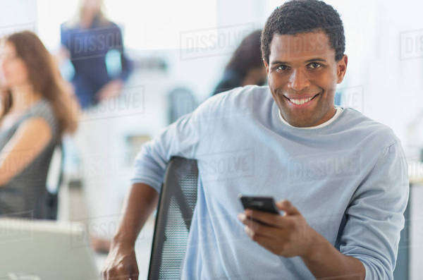 Man smiling at desk in office - Royalty-free Stock Photo | Dissolve