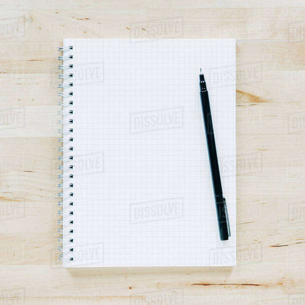 Overhead view of pen on notebook - Stock Photo - Dissolve
