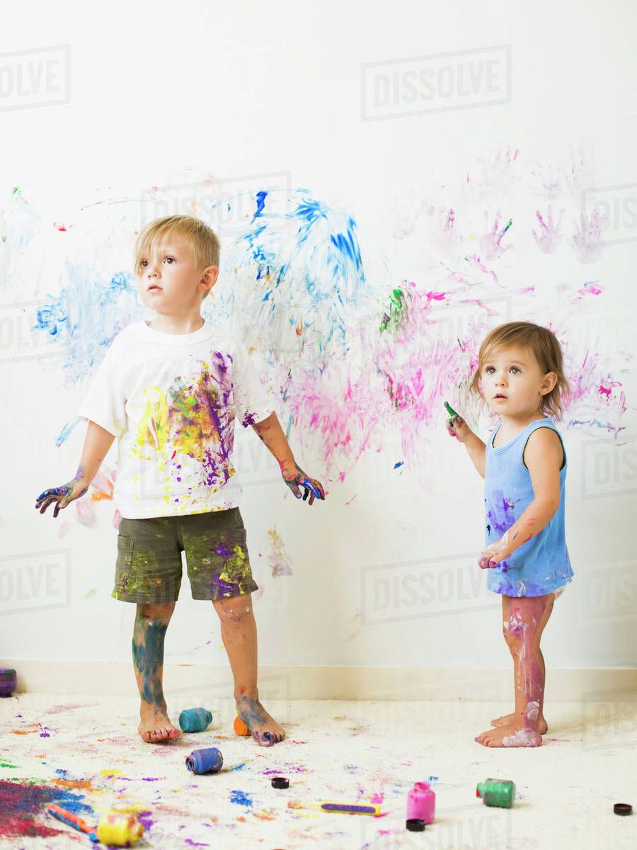 Children (2-3) painting on wall - Stock Photo - Dissolve