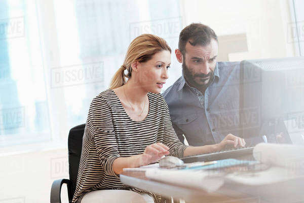 Man and woman looking at computer in office - Royalty-free Stock Photo ...