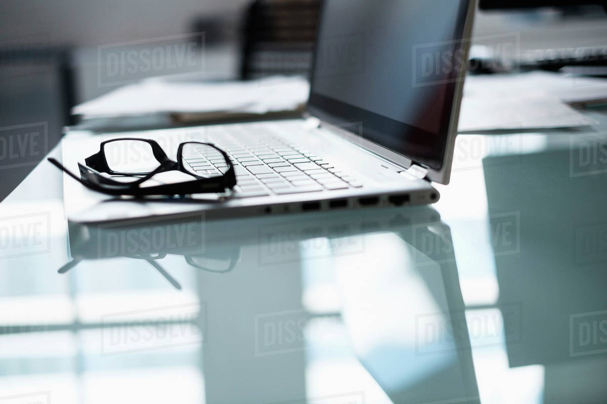 Eyeglasses and laptop on desk in office - Royalty-free Stock Photo ...