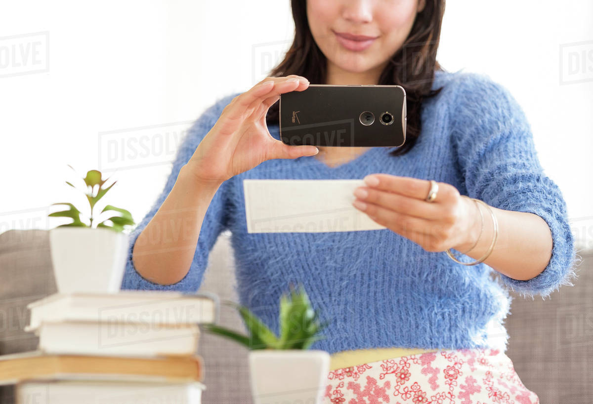 Young woman photographing bank statement - Stock Photo - Dissolve