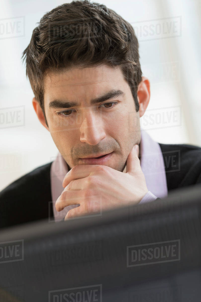 Business man looking at computer - Stock Photo - Dissolve