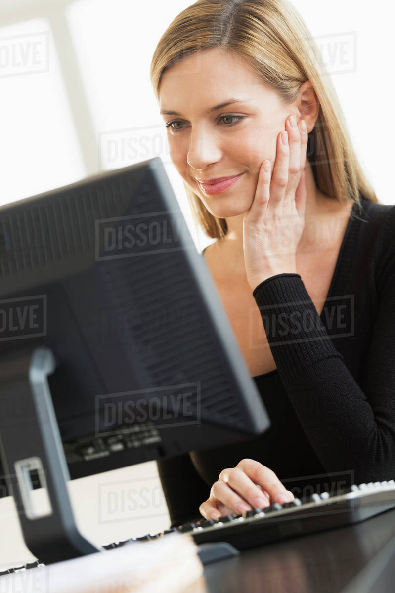 Business woman looking at computer - Stock Photo - Dissolve