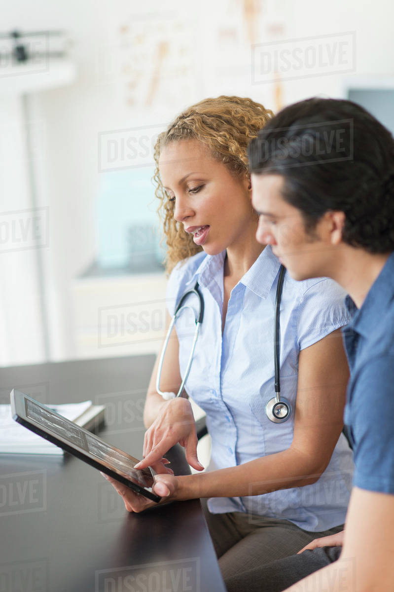 Doctor and patient talking in clinic using tablet pc - Stock Photo ...