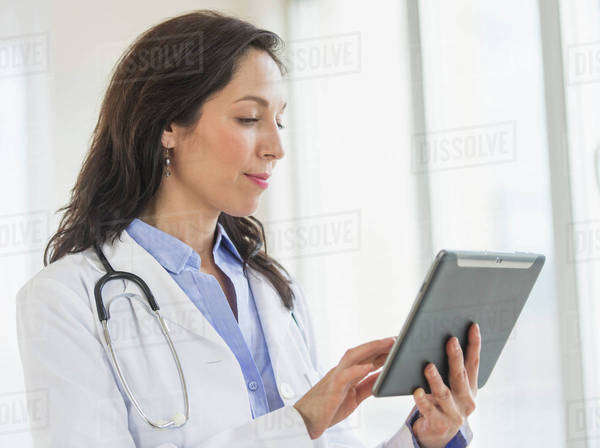Female doctor using digital tablet - Stock Photo - Dissolve