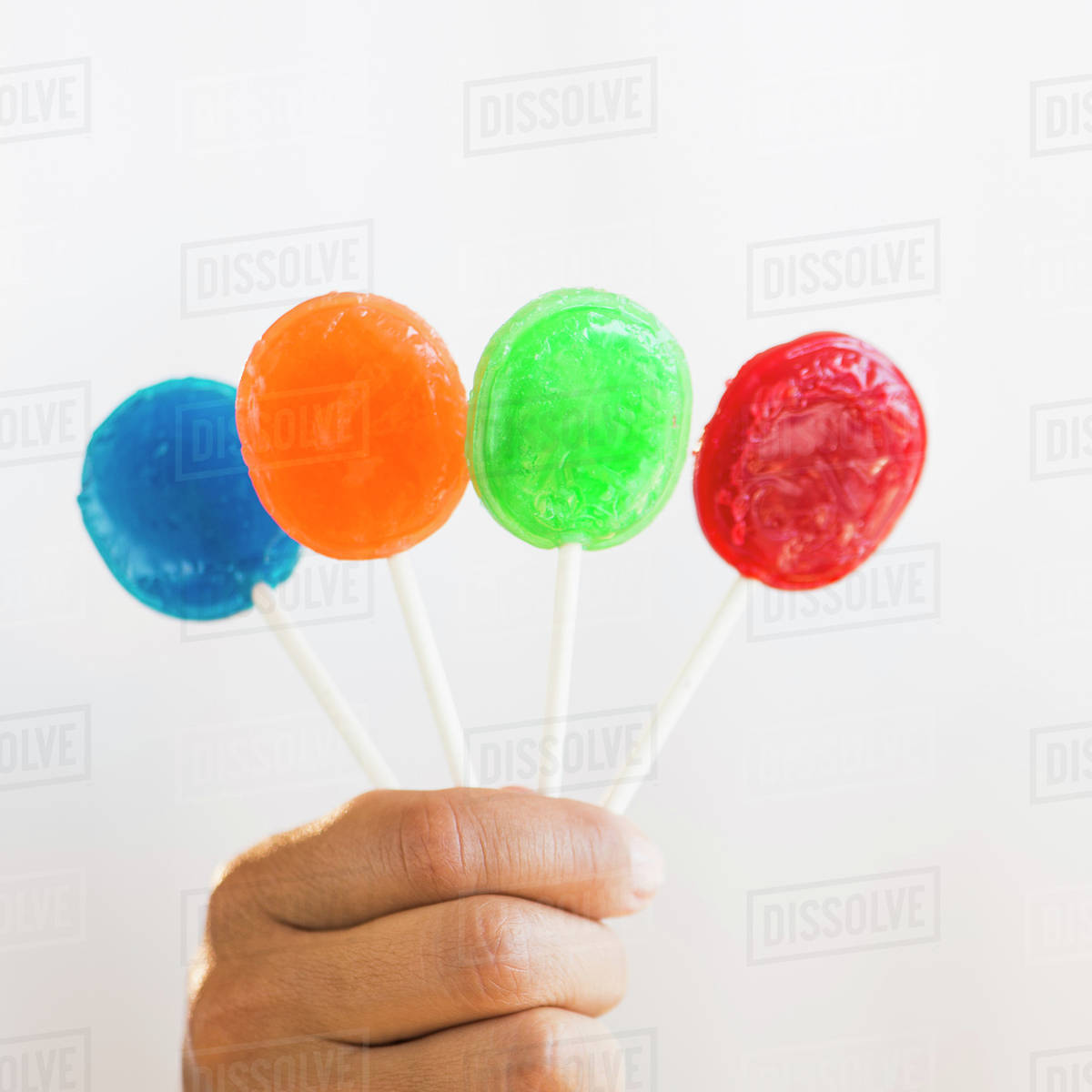 Hand holding colorful lollypops - Royalty-free Stock Photo | Dissolve