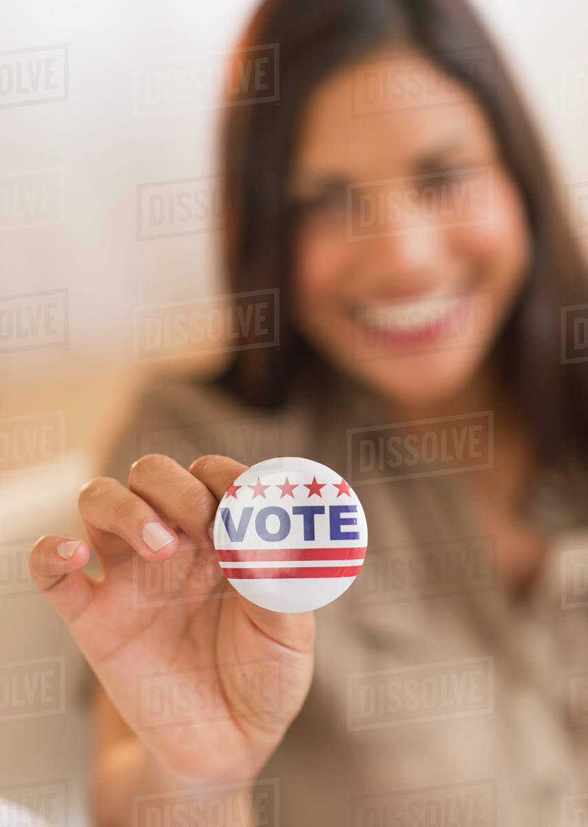 Woman holding vote button - Royalty-free Stock Photo | Dissolve