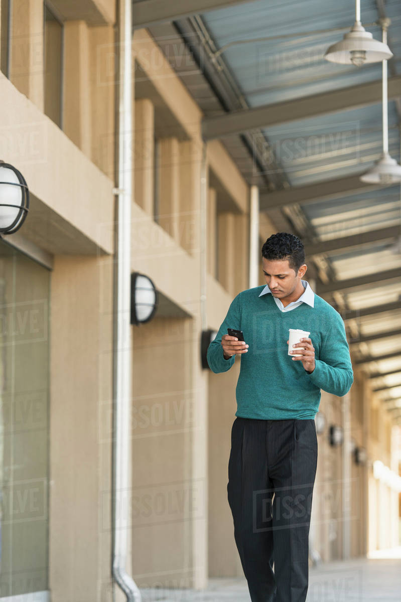 Man walking outside building and text messaging - Royalty-free Stock ...