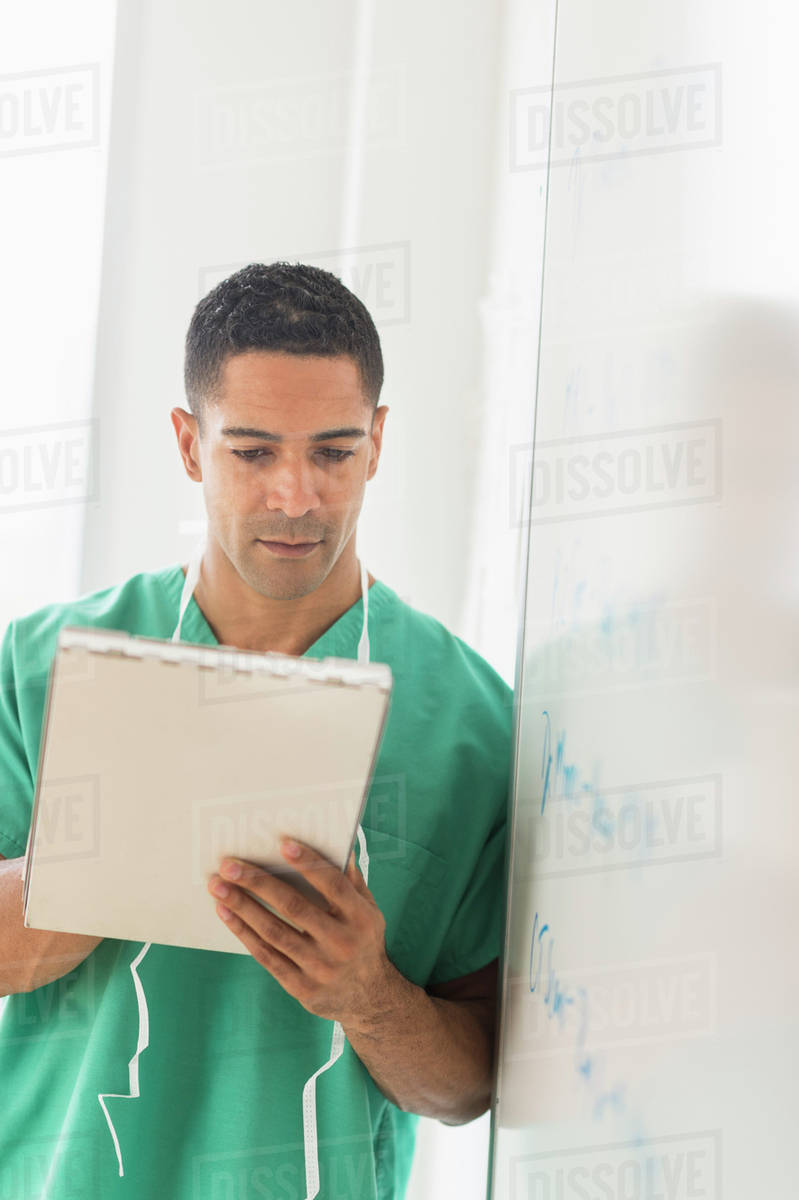 Male surgeon reading medical chart in hospital - Royalty-free Stock ...