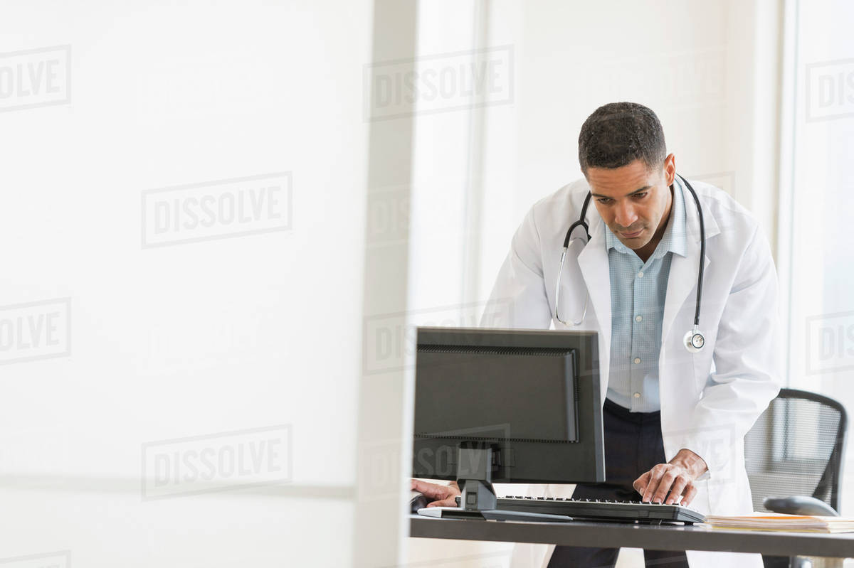 Male doctor using computer in his office - Royalty-free Stock Photo ...