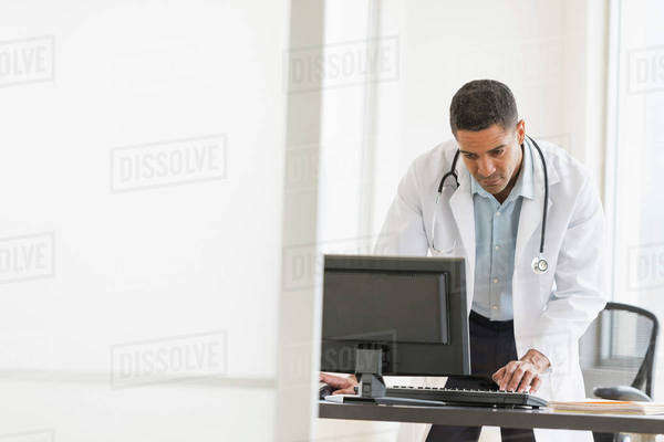 Male doctor using computer in his office - Royalty-free Stock Photo ...