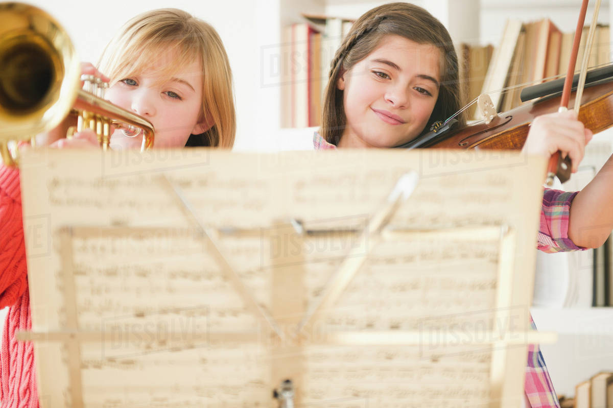 Two girls playing instruments from sheet music - Royalty-free Stock ...