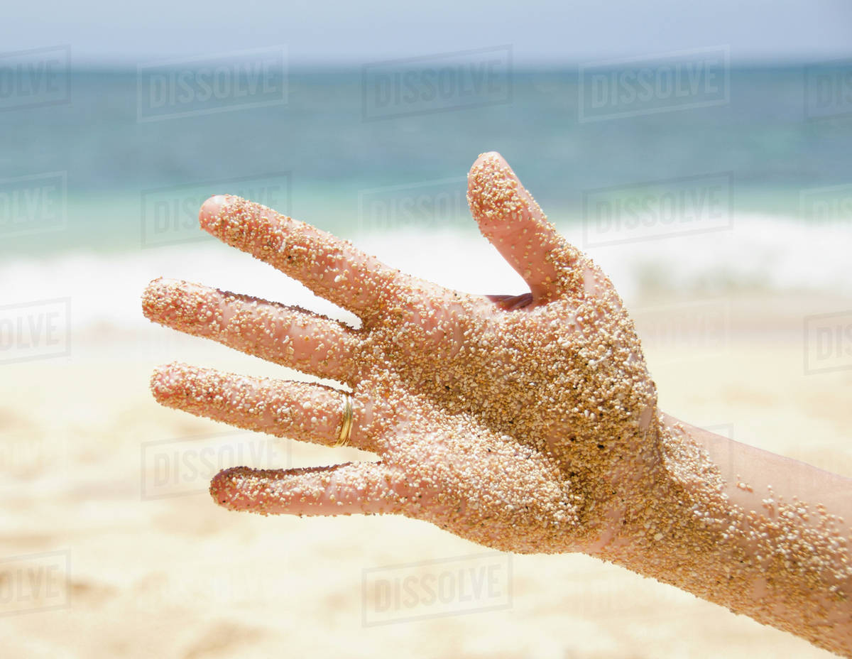 Woman's hand with sticking sand - Stock Photo - Dissolve