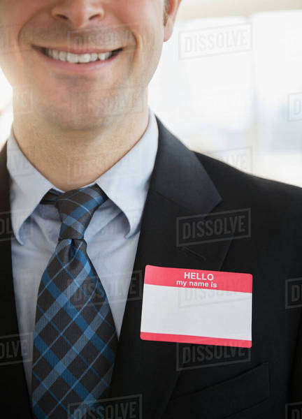 Office worker with name tag on suit - Stock Photo - Dissolve