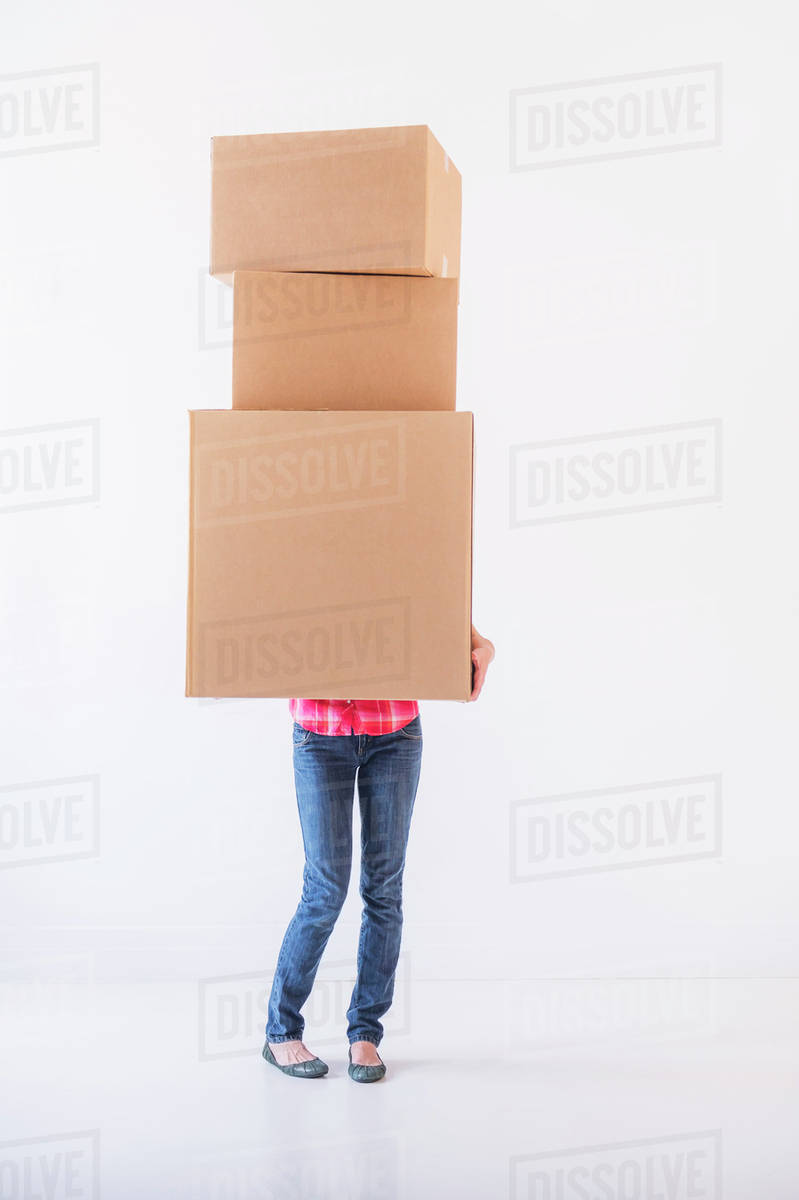 Studio shot of young woman carrying stack of boxes - Royalty-free Stock ...