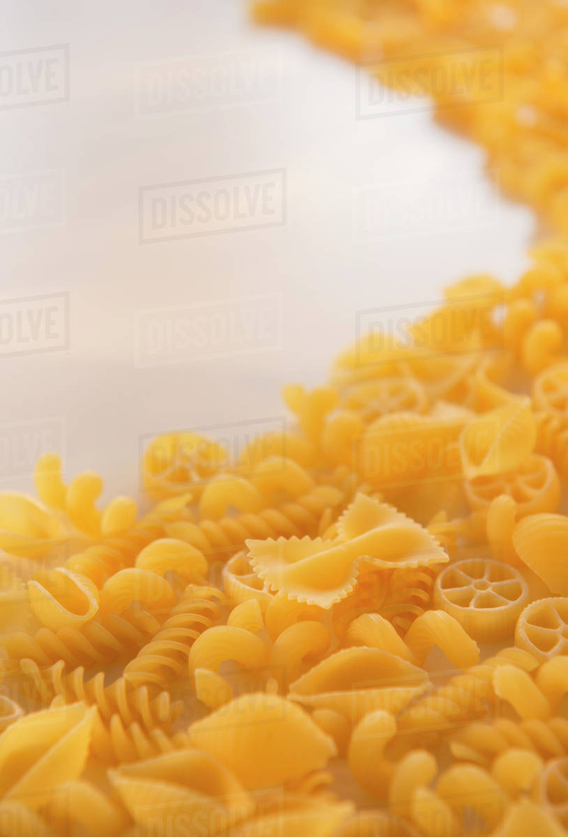 Variety of yellow pasta with blank white space in upper left corner ...