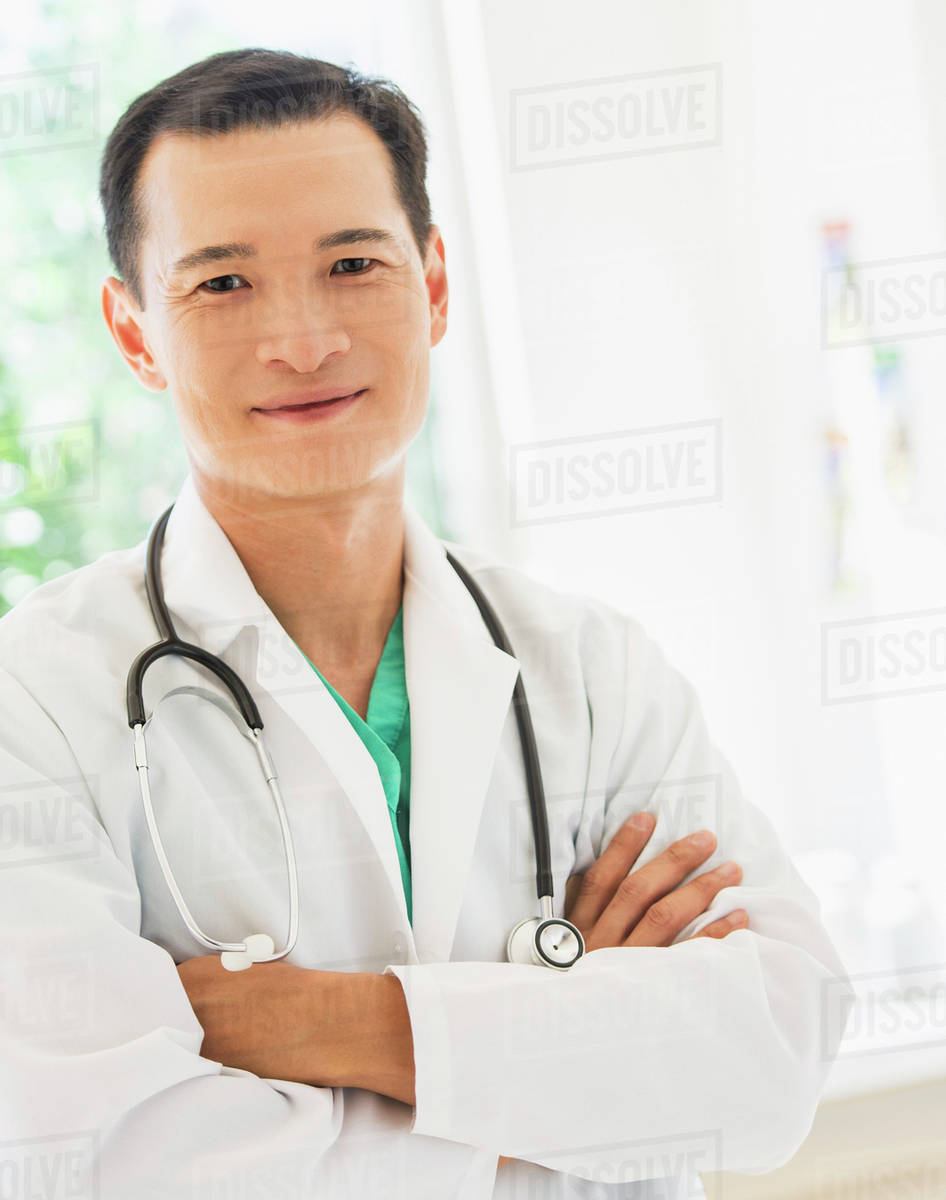 Portrait of happy mid adult doctor - Stock Photo - Dissolve