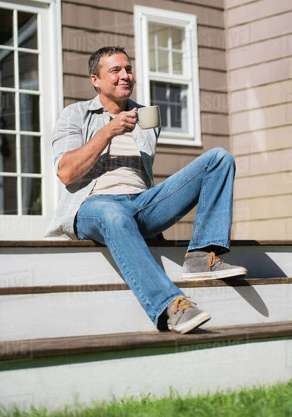 Portrait of man sitting on steps - Stock Photo - Dissolve