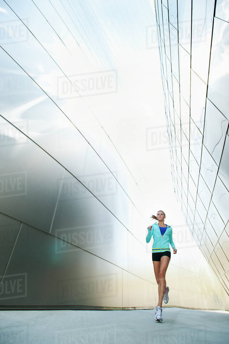 USA, California, Los Angeles, Young woman jogging in city - Royalty ...