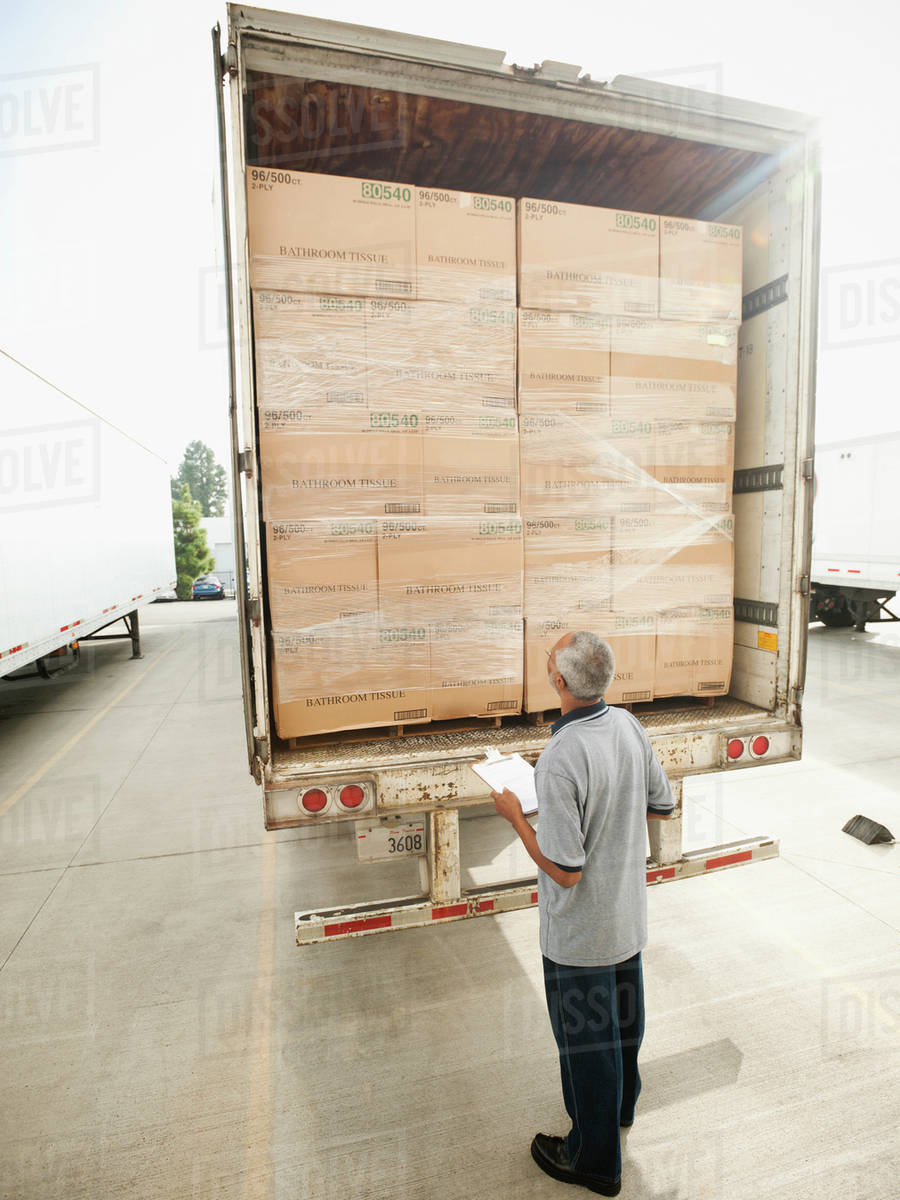 Man checking load on truck trailer - Stock Photo - Dissolve