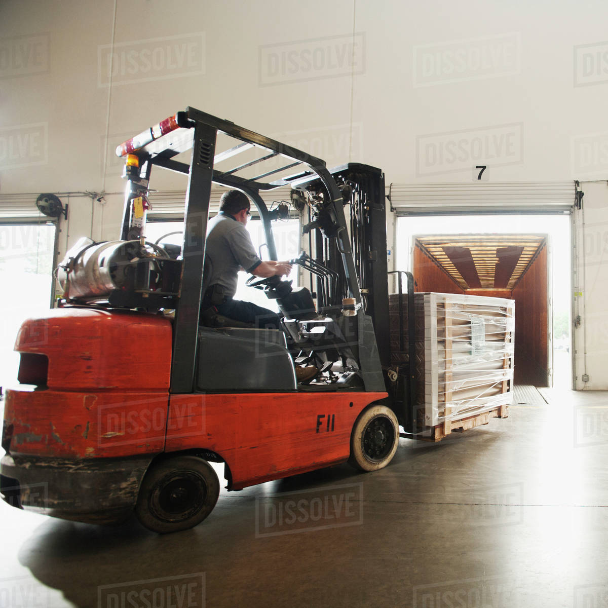 Forklift driver working in warehouse - Royalty-free Stock Photo | Dissolve