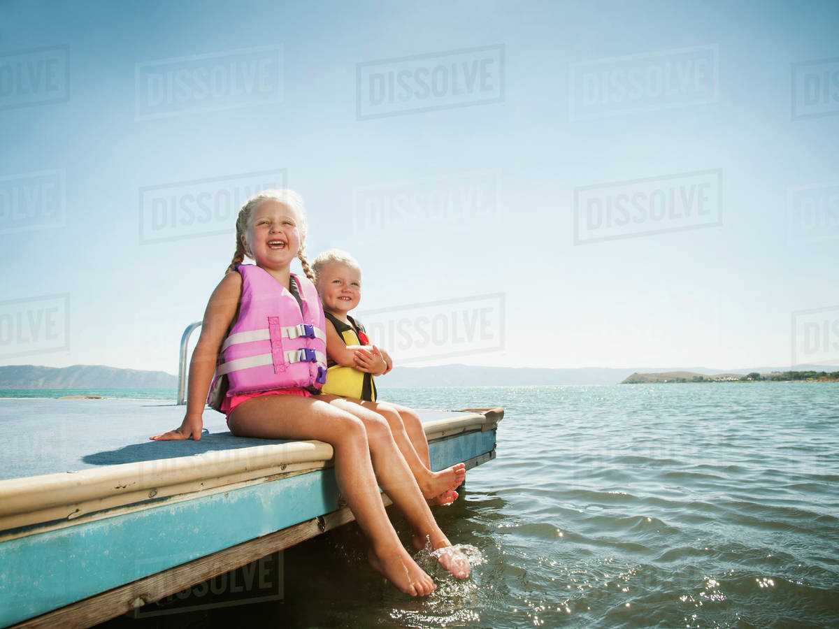 Girls (2-3, 4-5) sitting at the edge of raft in life jackets - Stock ...