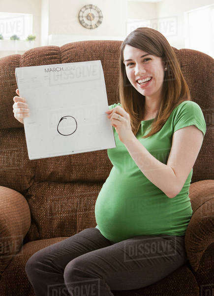 Portrait of pregnant woman showing calendar with due date - Stock Photo ...