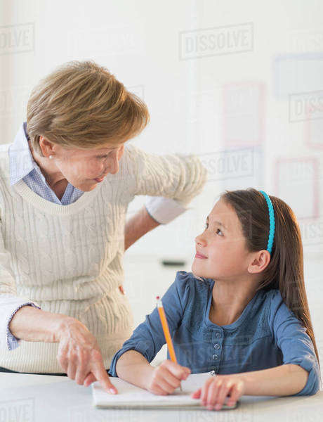 Teacher helping schoolgirl (8-9) at school - Royalty-free Stock Photo ...