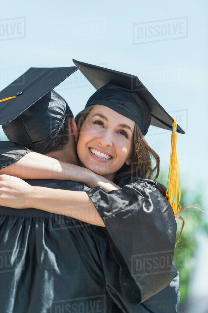 Female and male student embracing on graduation ceremony - Royalty-free ...