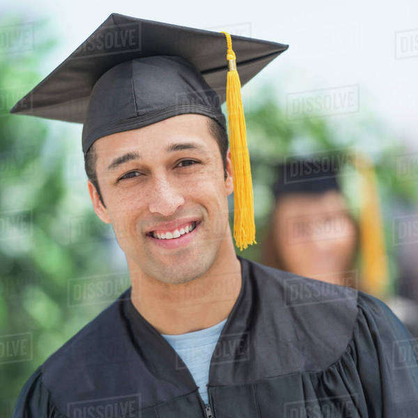 Portrait of male student on graduation ceremony with female student in ...
