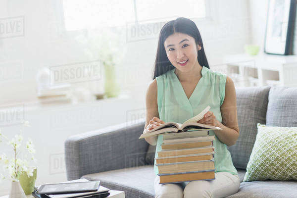 Woman with stack of books at home - Royalty-free Stock Photo | Dissolve