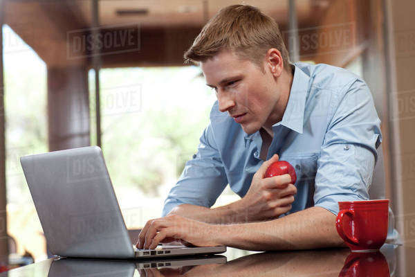 Man using laptop at home - Royalty-free Stock Photo | Dissolve
